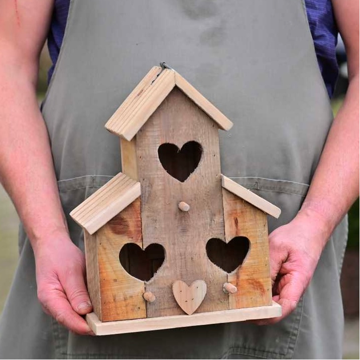 Three winged bird house with heart shaped openings and opening on the ...